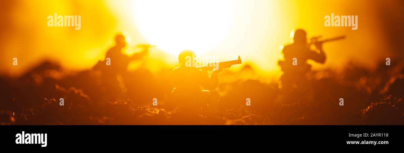 Battle scene of toy soldiers with sun on orange background, panoramic ...