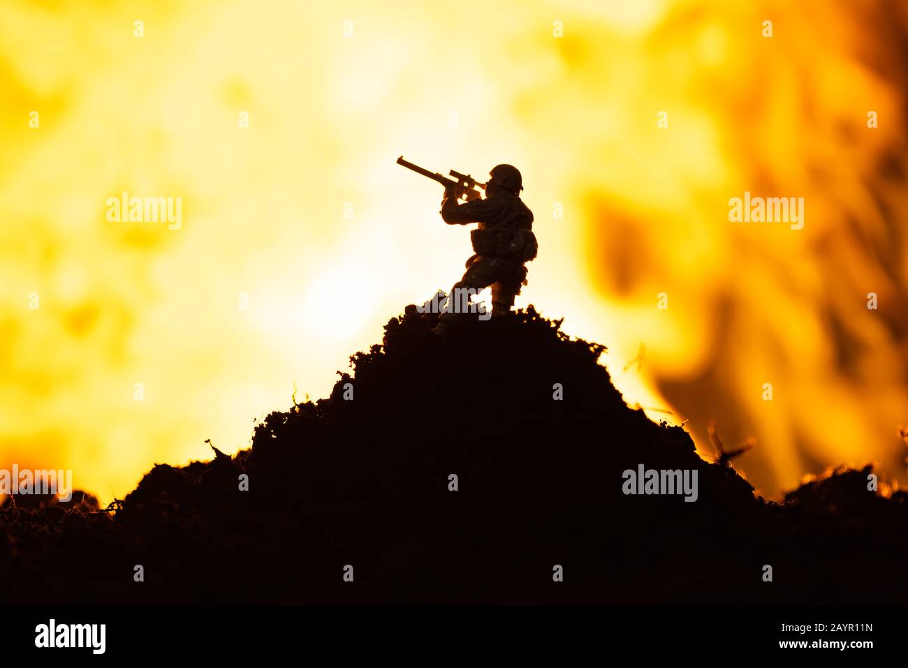 Battle scene with toy warrior on battleground and fire at background ...
