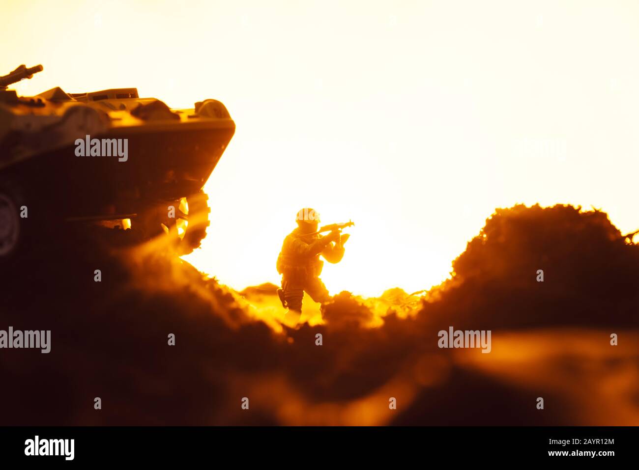 Battle scene with toy soldier near tank on battleground on yellow ...