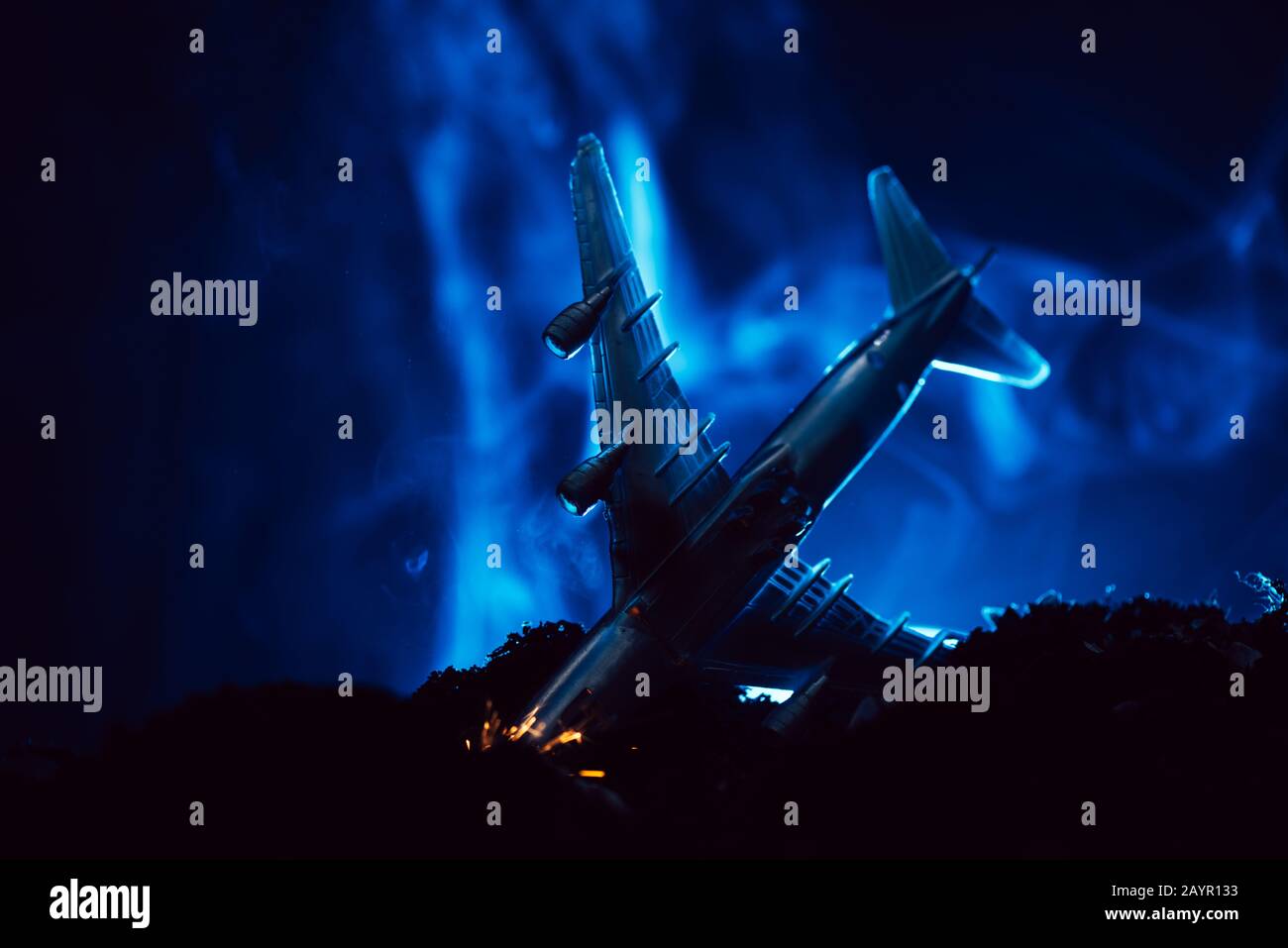 Battle scene with crash of toy plane with blue smoke on black ...