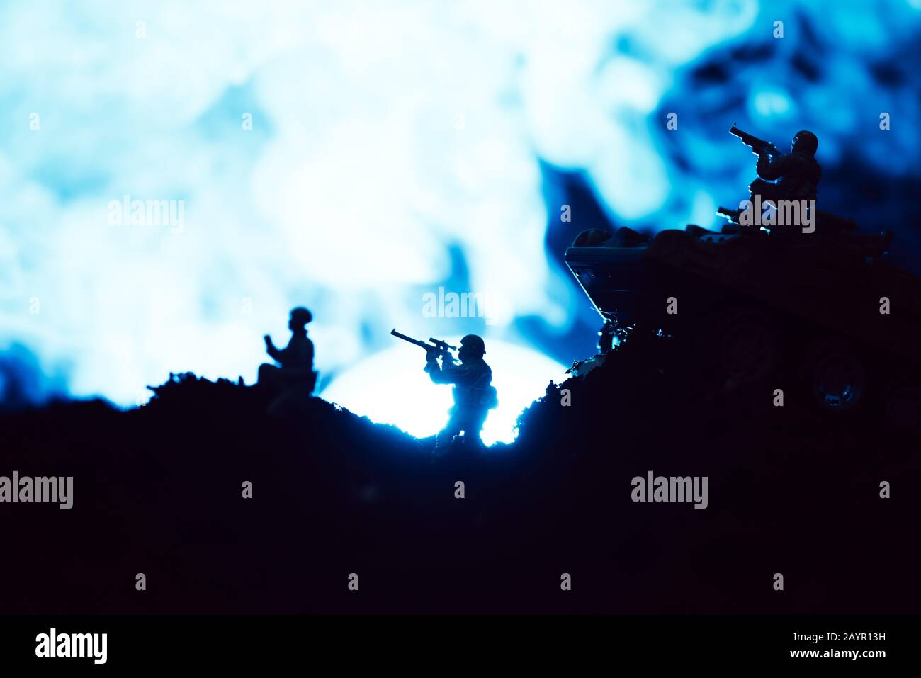 Battle scene with toy soldiers and smoke with moon on black background ...