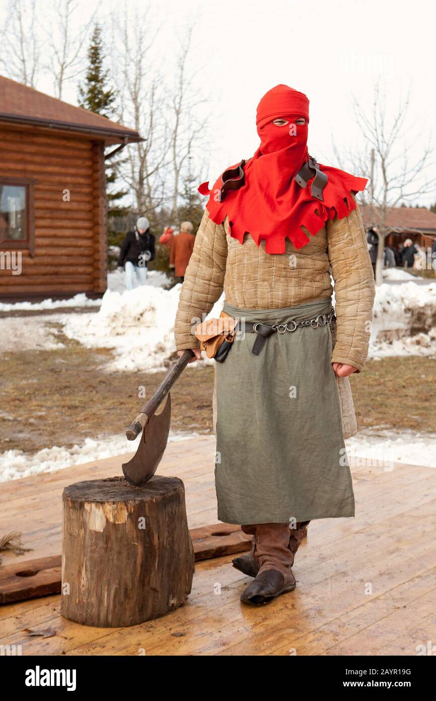 Medieval age executor with red hat and axe fair Stock Photo - Alamy
