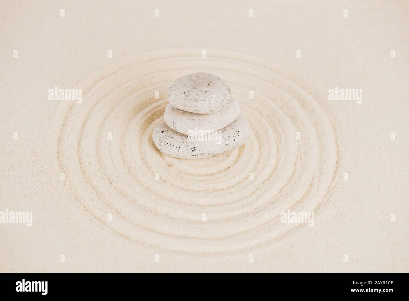 Stack of zen stones on sand surface with circles Stock Photo - Alamy