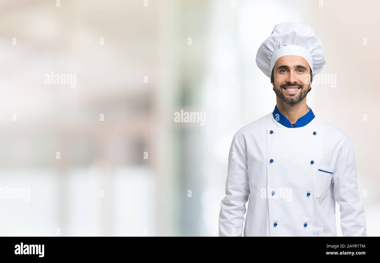 Smiling chef in front of a large wide bright background Stock Photo - Alamy
