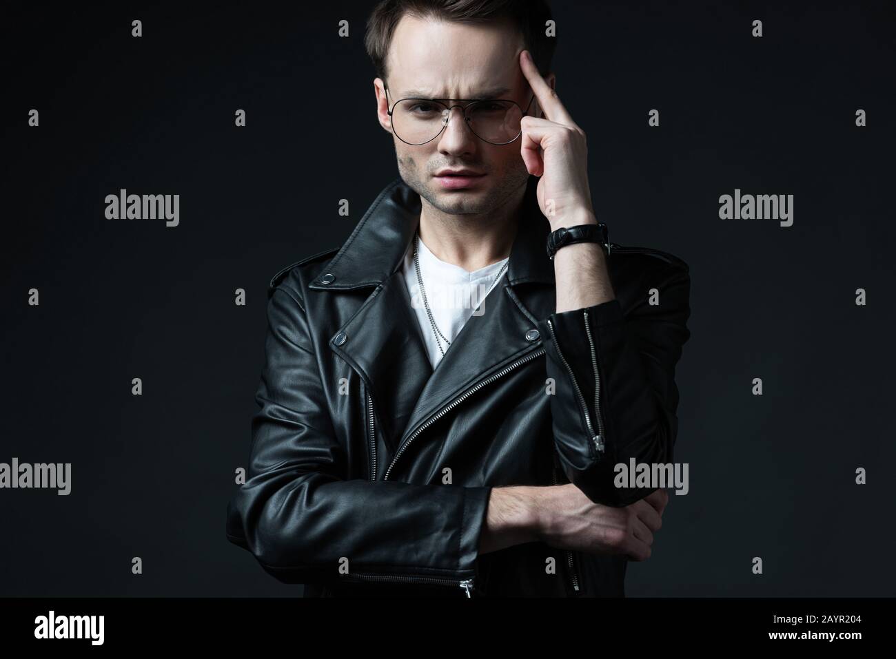tense stylish brutal man in biker jacket thinking isolated on black ...