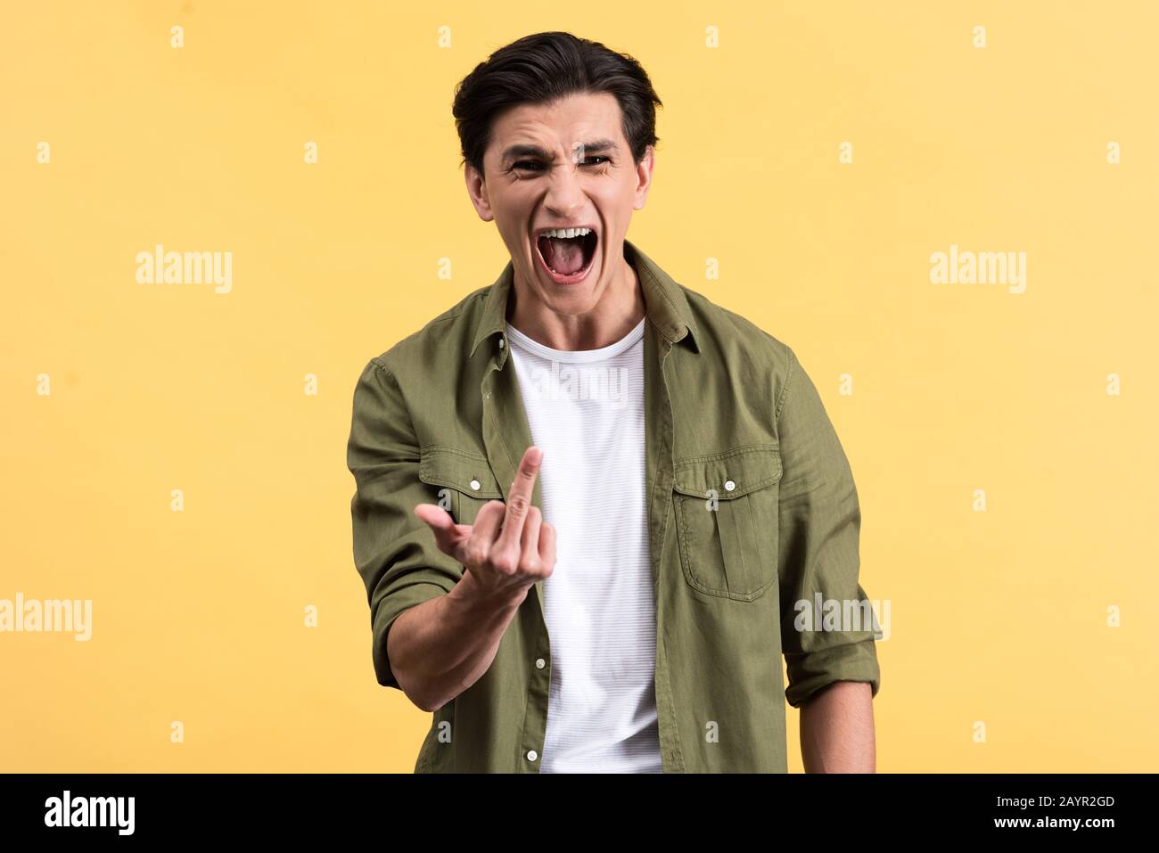 aggressive young man screaming and showing middle finger, isolated on ...