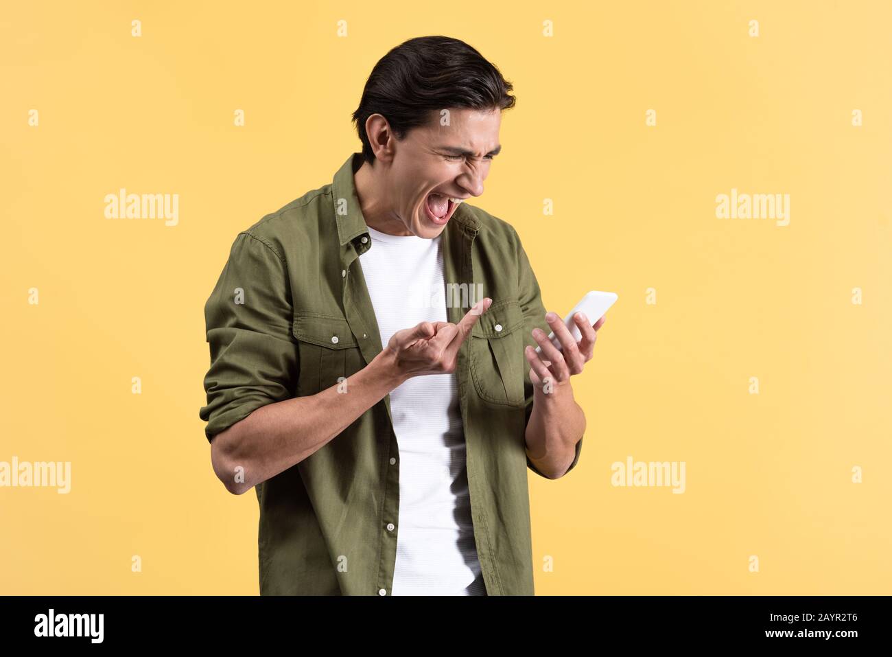 aggressive young man yelling and showing middle finger to smartphone ...