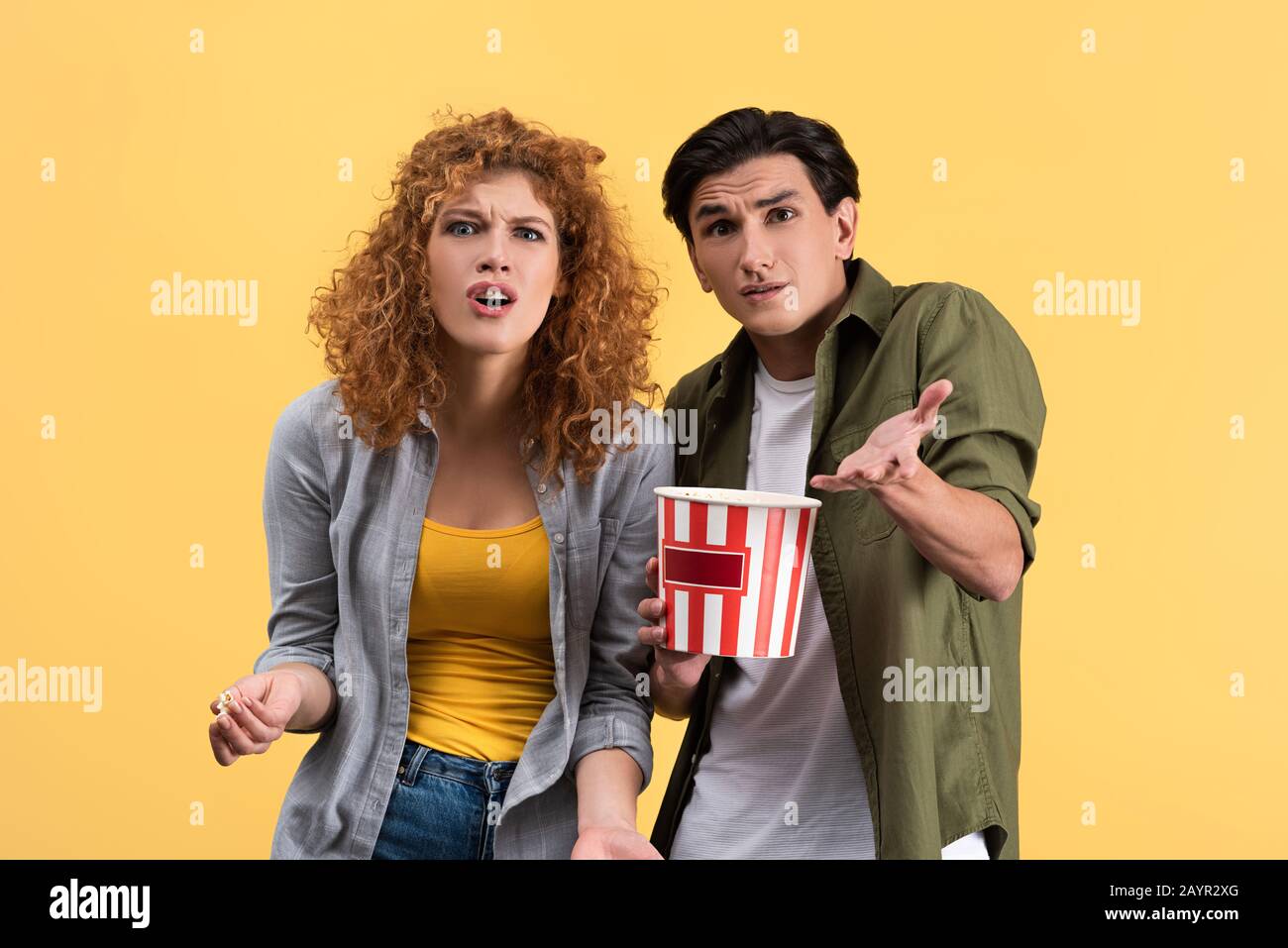 irritated couple watching bad movie with bucket of popcorn, isolated on ...