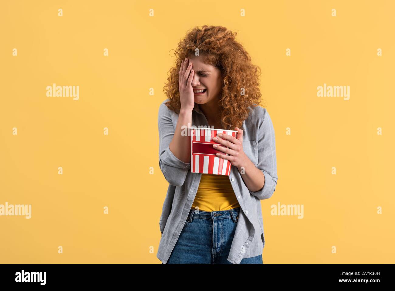 upset girl crying and watching movie with bucket of popcorn, isolated ...