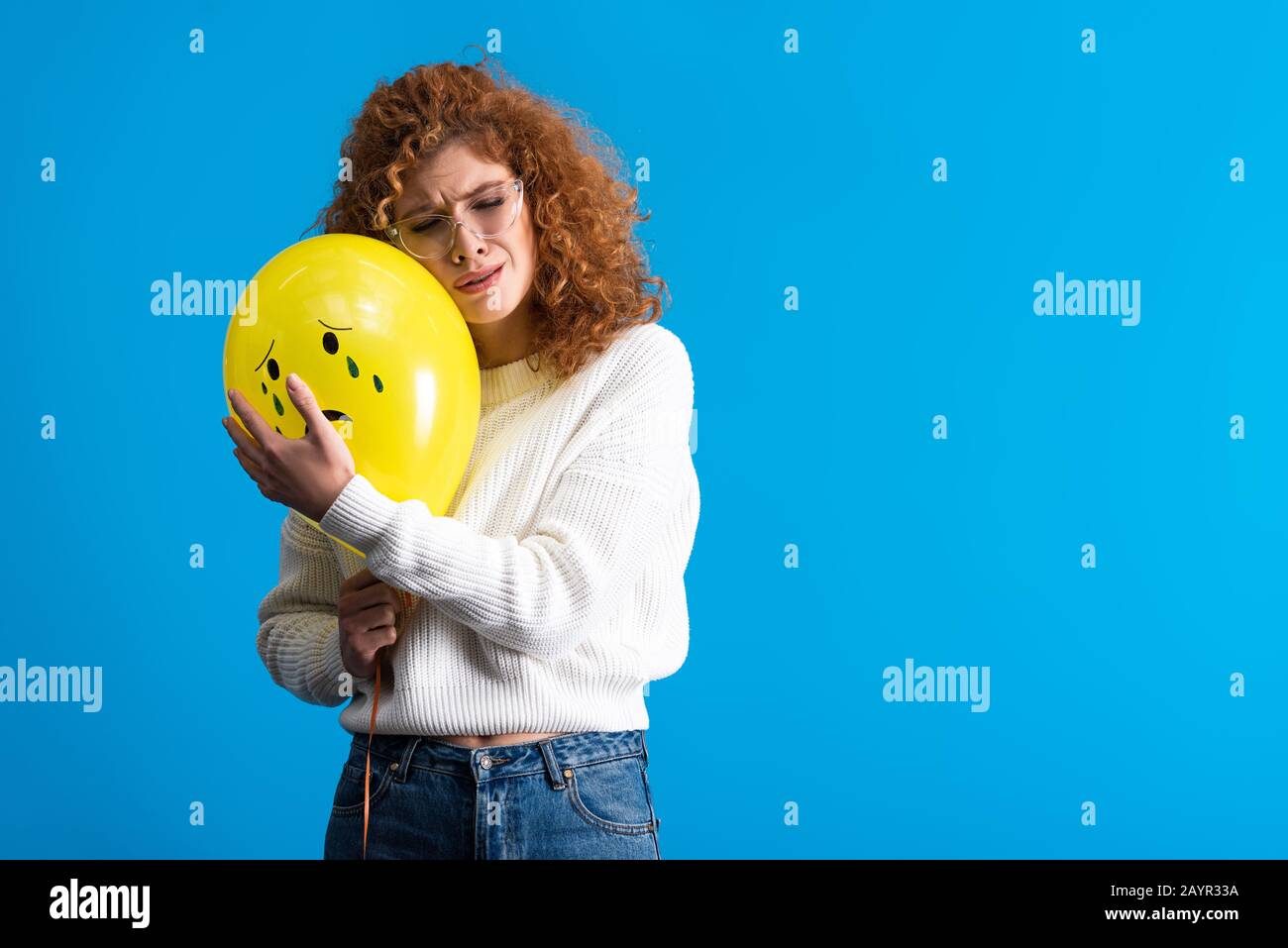sad redhead girl holding yellow balloon with crying face, isolated on ...