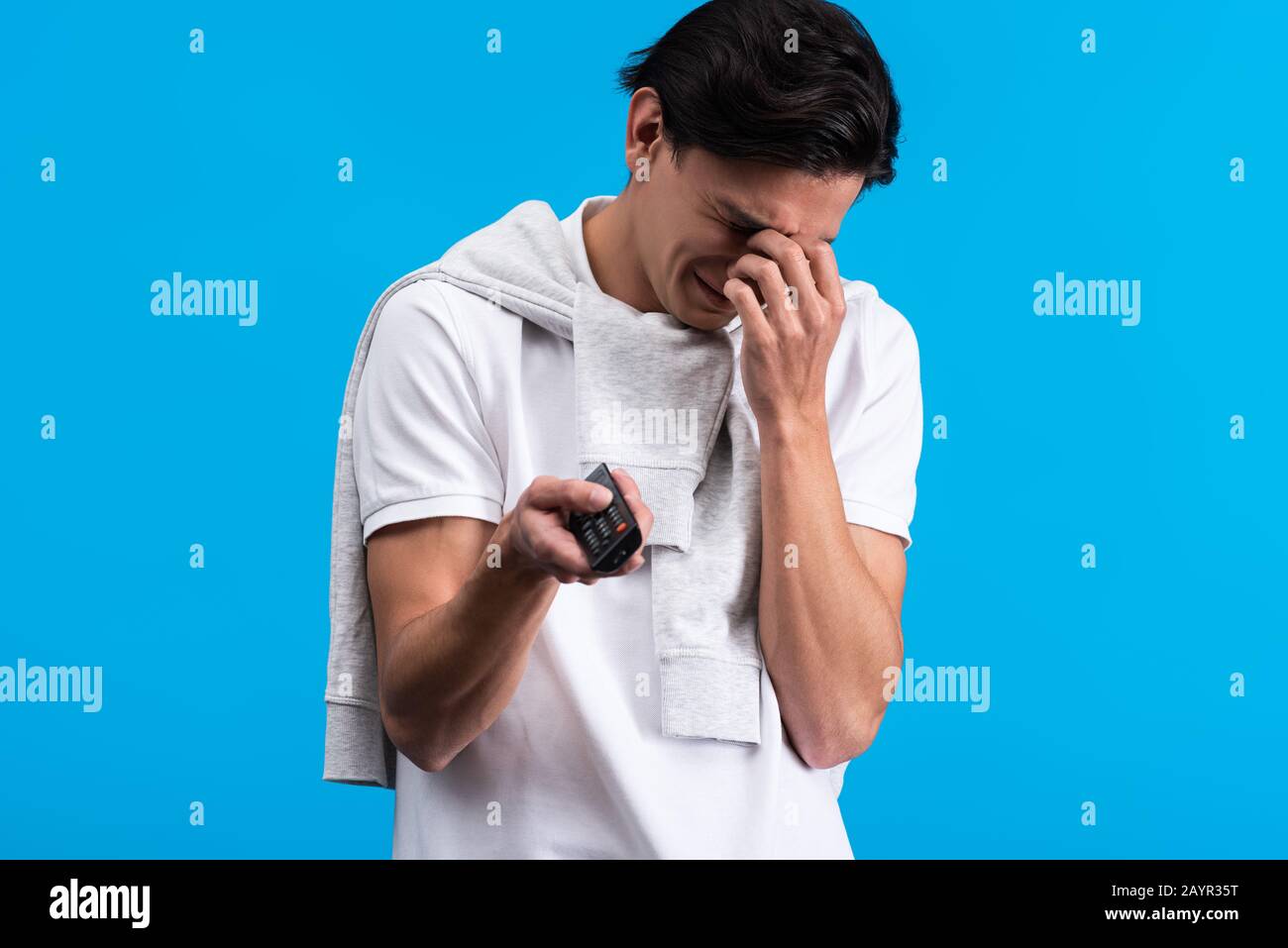 sad man crying while watching tv with remote controller, isolated on ...