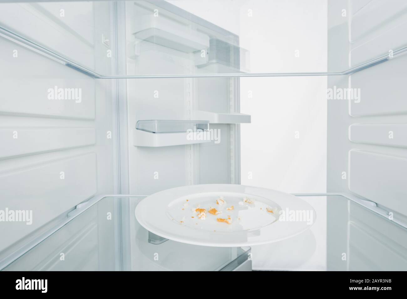 Plate with crumbs in refrigerator with open door isolated on white ...
