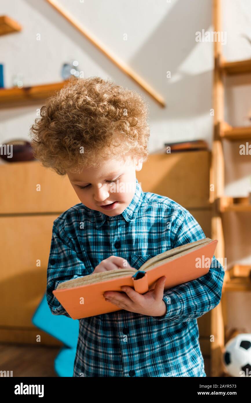 smart child smiling while reading book Stock Photo - Alamy