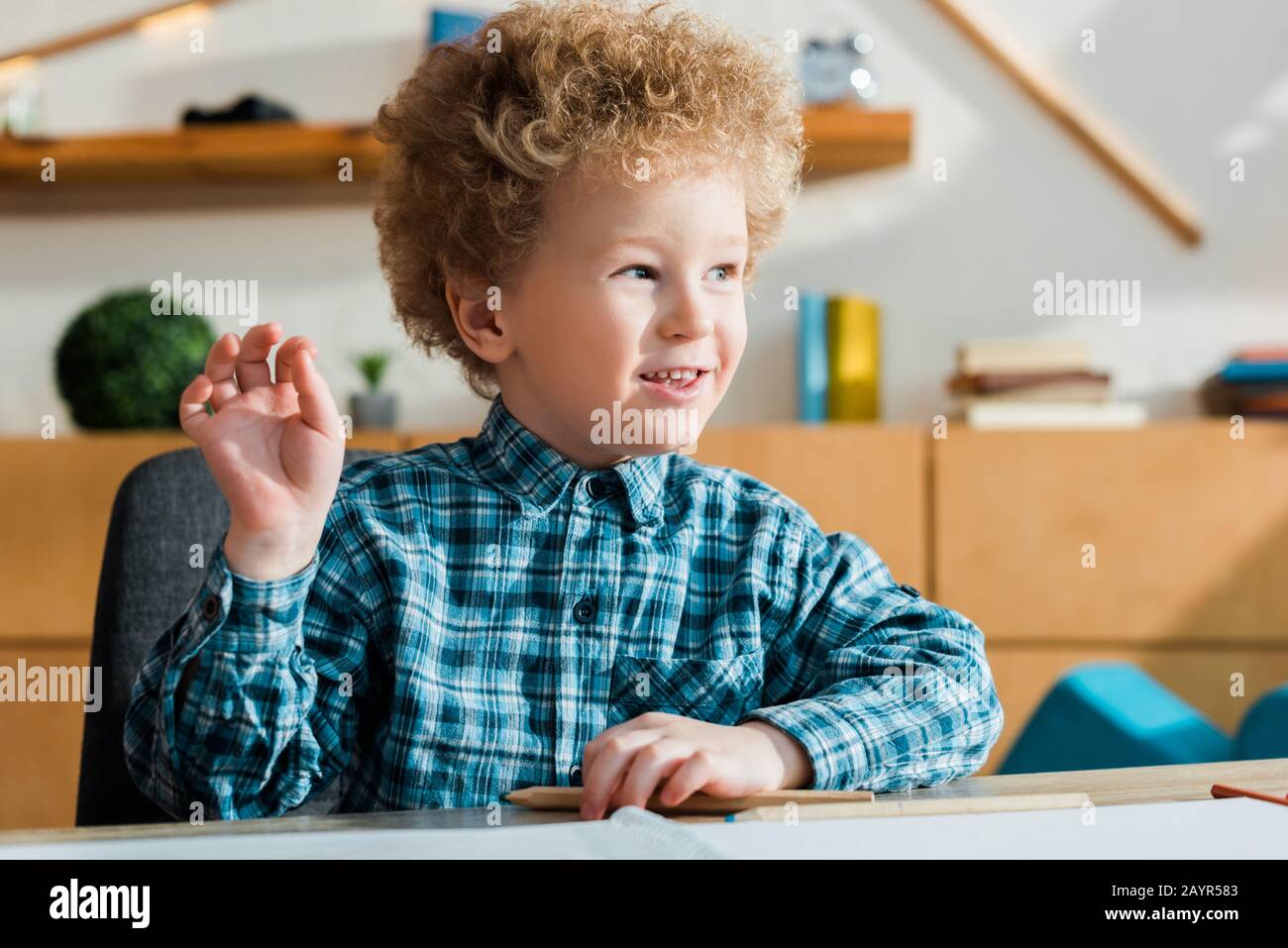 smart and curly kid with raised hand looking away Stock Photo - Alamy