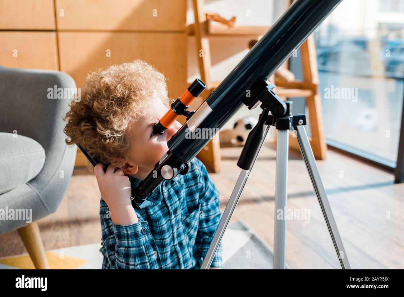 smart child looking through telescope at home Stock Photo - Alamy