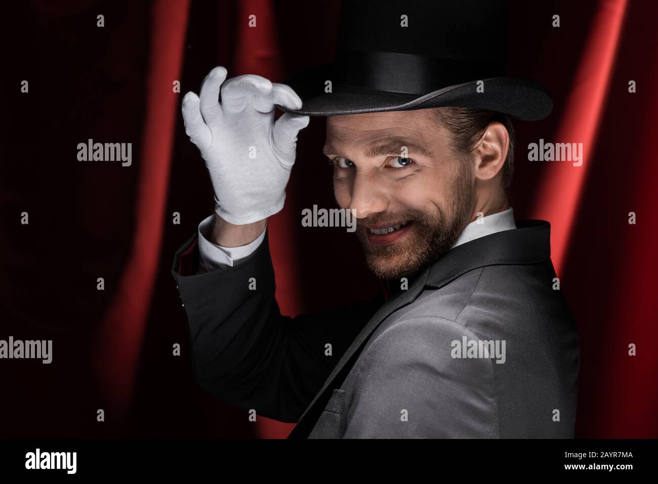 scary smiling magician in circus with red curtains Stock Photo - Alamy