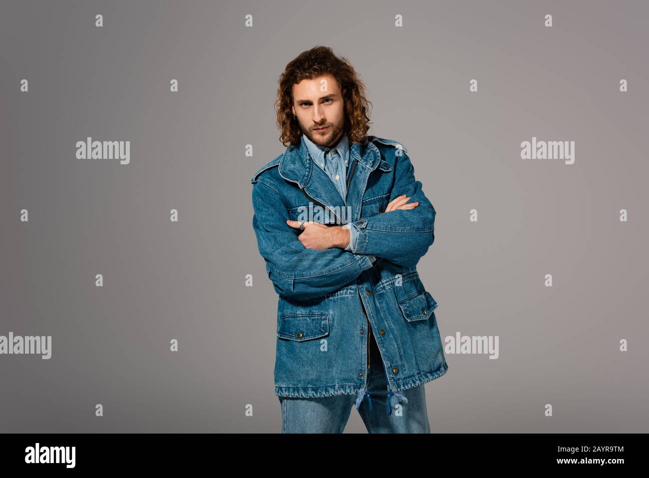 stylish man in denim jacket and jeans with crossed arms isolated on ...