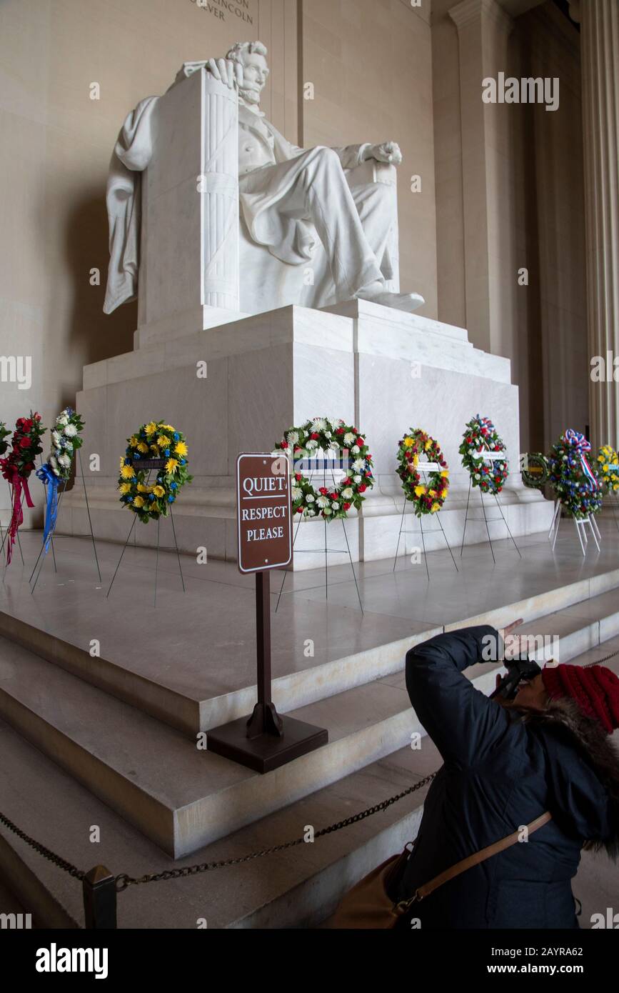 A visitor photographs the statue of Abraham Lincoln with commemorative ...