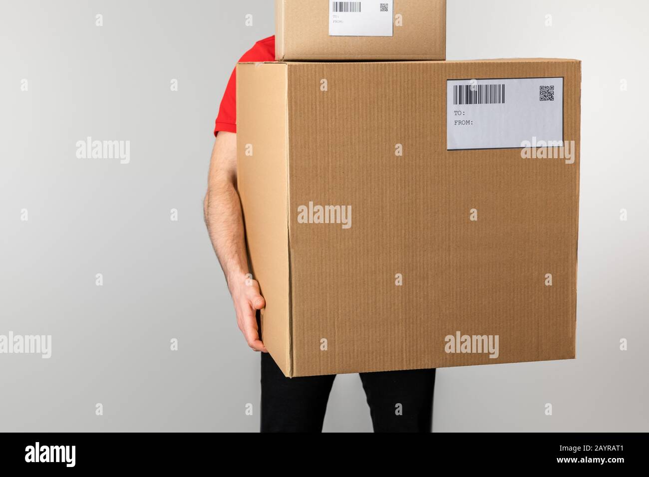 Delivery man holding boxes with barcodes and qr codes on cards isolated ...