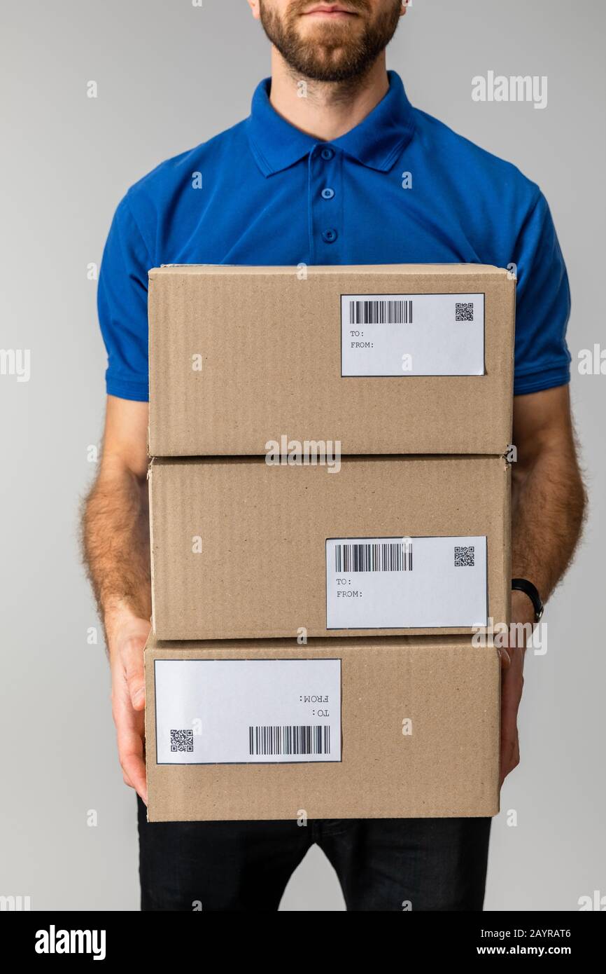 Cropped view of courier holding boxes with barcodes and qr codes ...