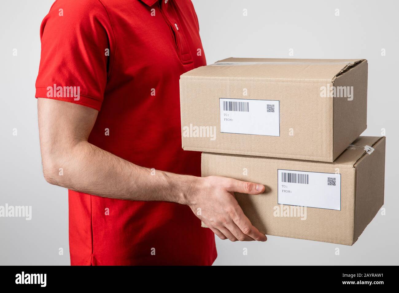 Cropped view of courier carrying cardboard packages with qr codes and ...