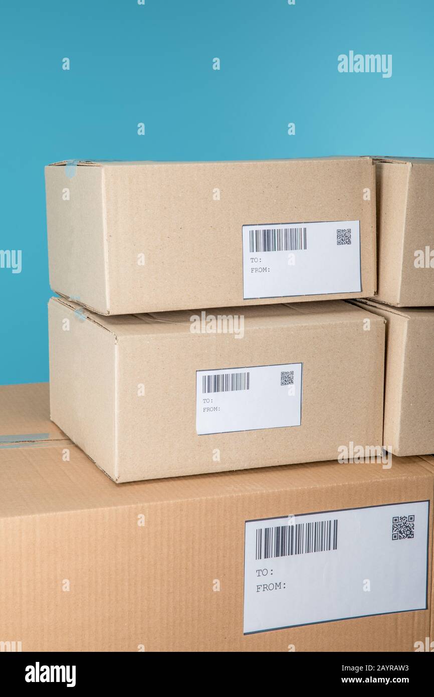 Stacked cardboard packages with barcodes and qr codes isolated on blue ...