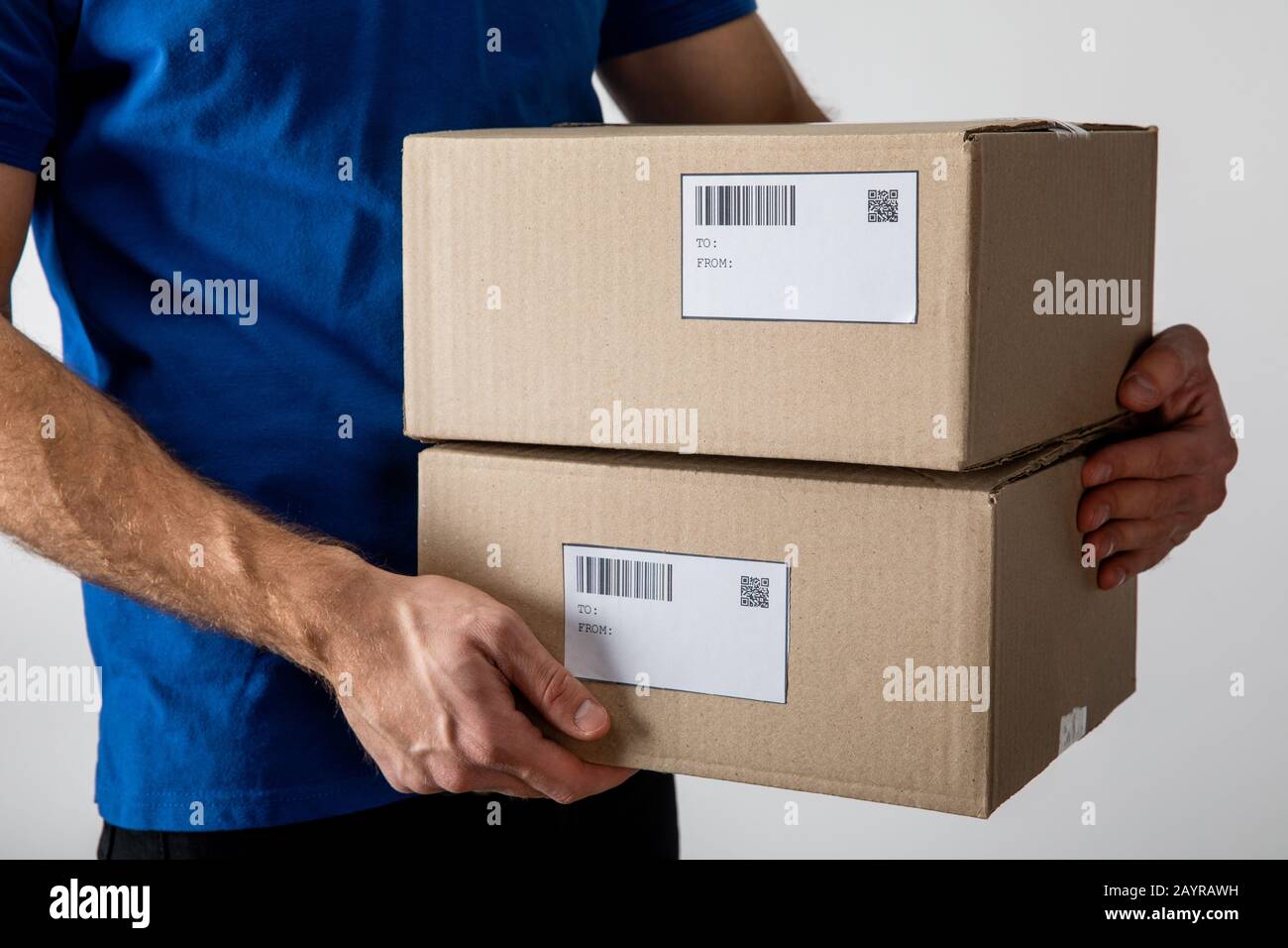 Cropped view of courier holding boxes with barcodes and qr codes on ...