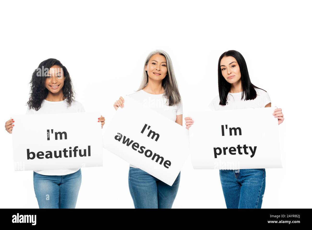 happy multicultural women holding posters with lettering isolated on ...
