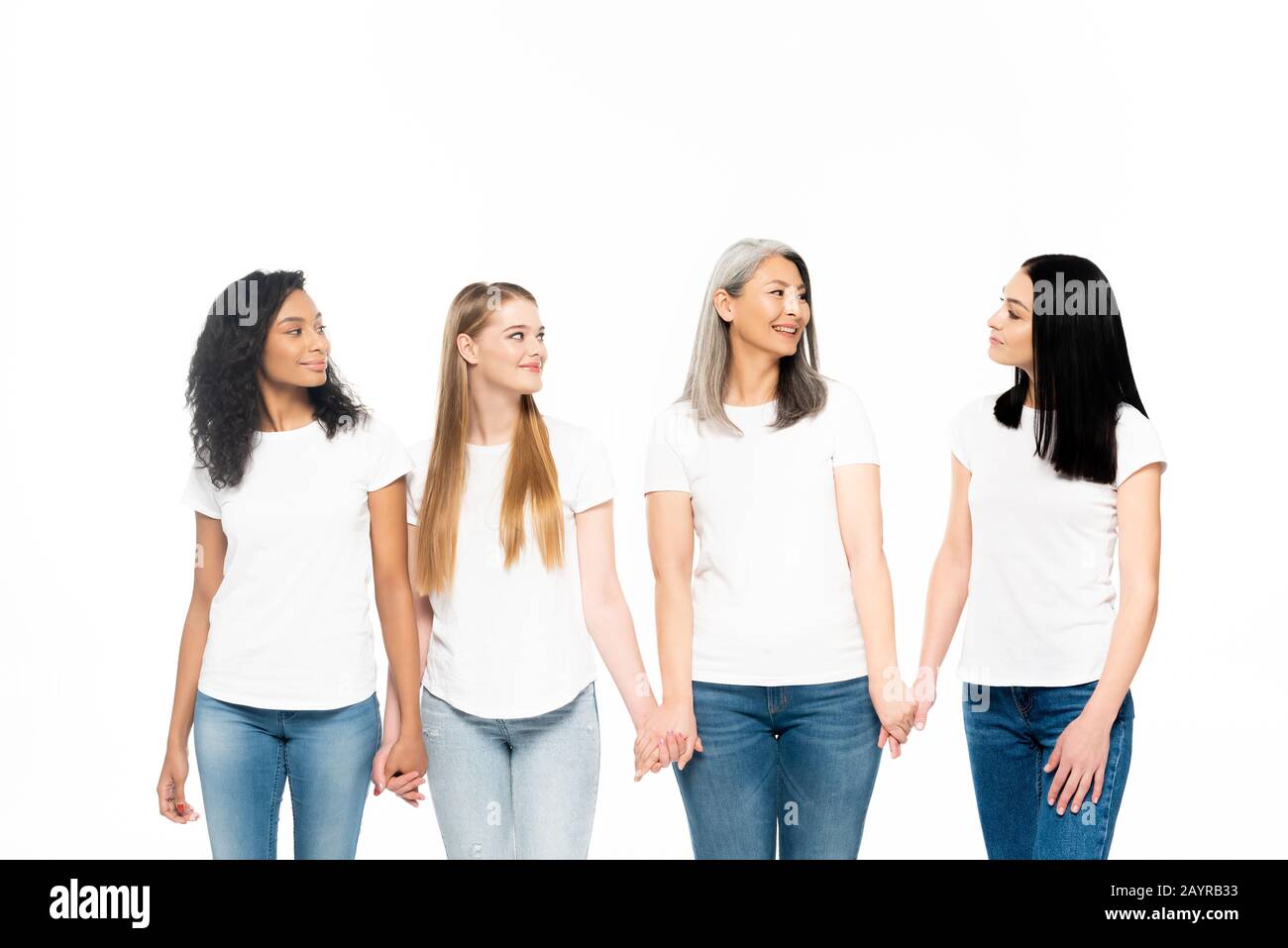 happy multicultural women in denim jeans holding hands isolated on ...