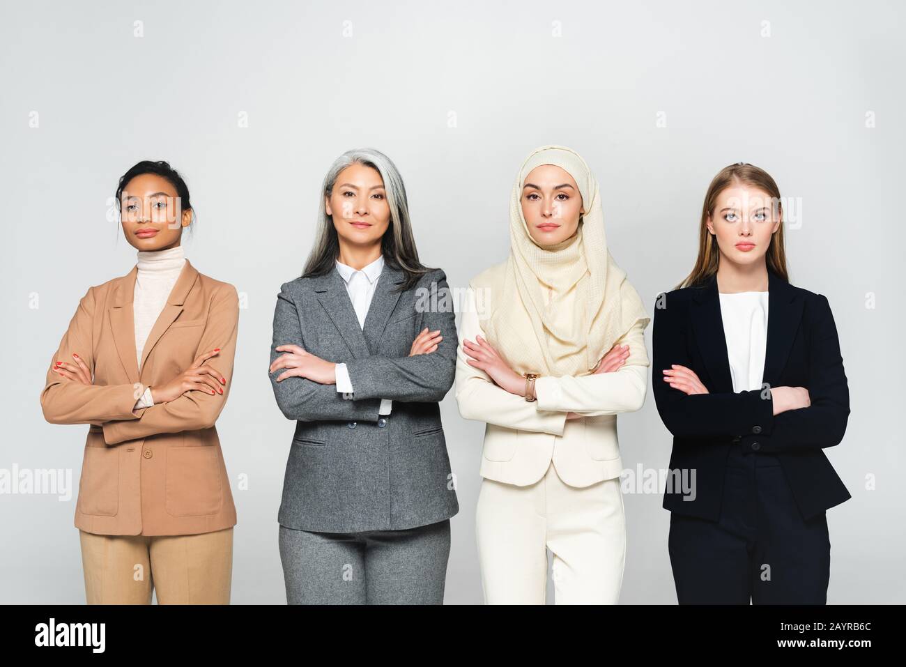 beautiful multicultural women standing with crossed arms isolated on ...