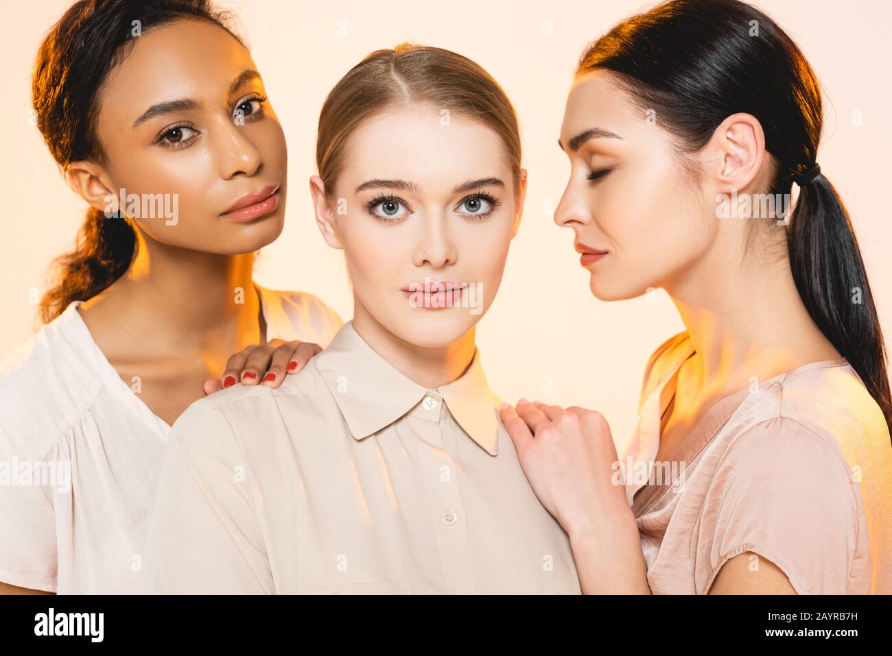three beautiful multicultural women with makeup isolated on beige Stock ...