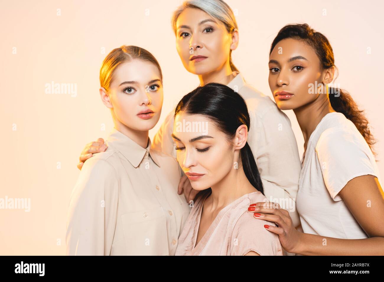 four attractive multicultural women with makeup isolated on beige Stock ...