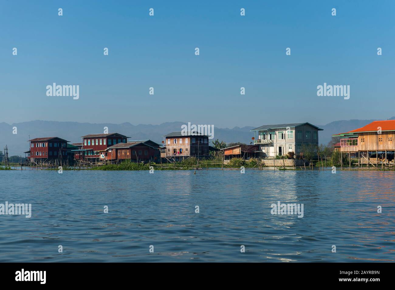A village scene with houses on stilts in a village in Inle Lake in ...
