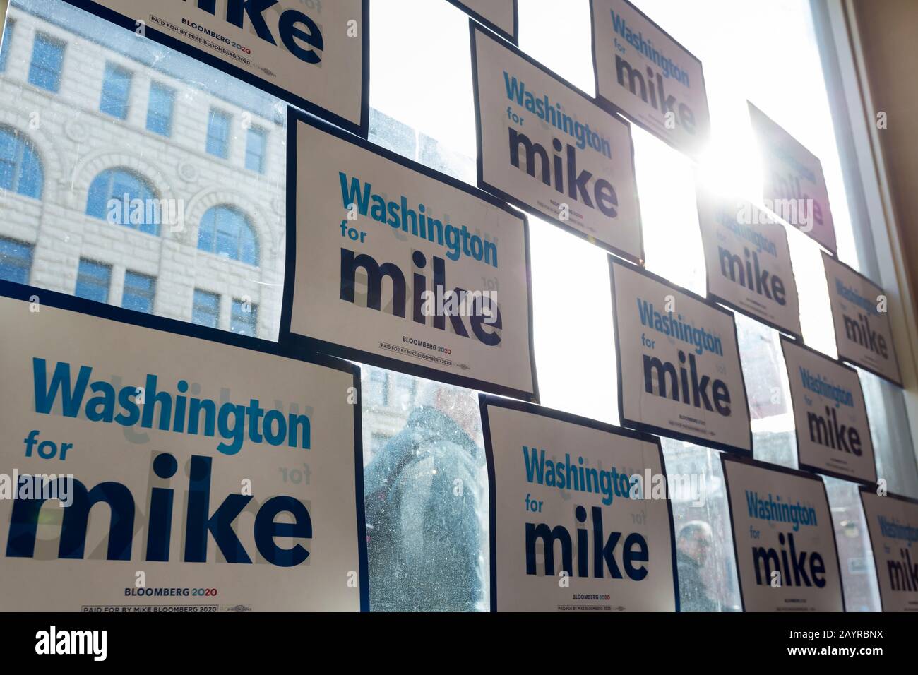 Two men look inside the window of Mike Bloomberg's Seattle headquarters ...