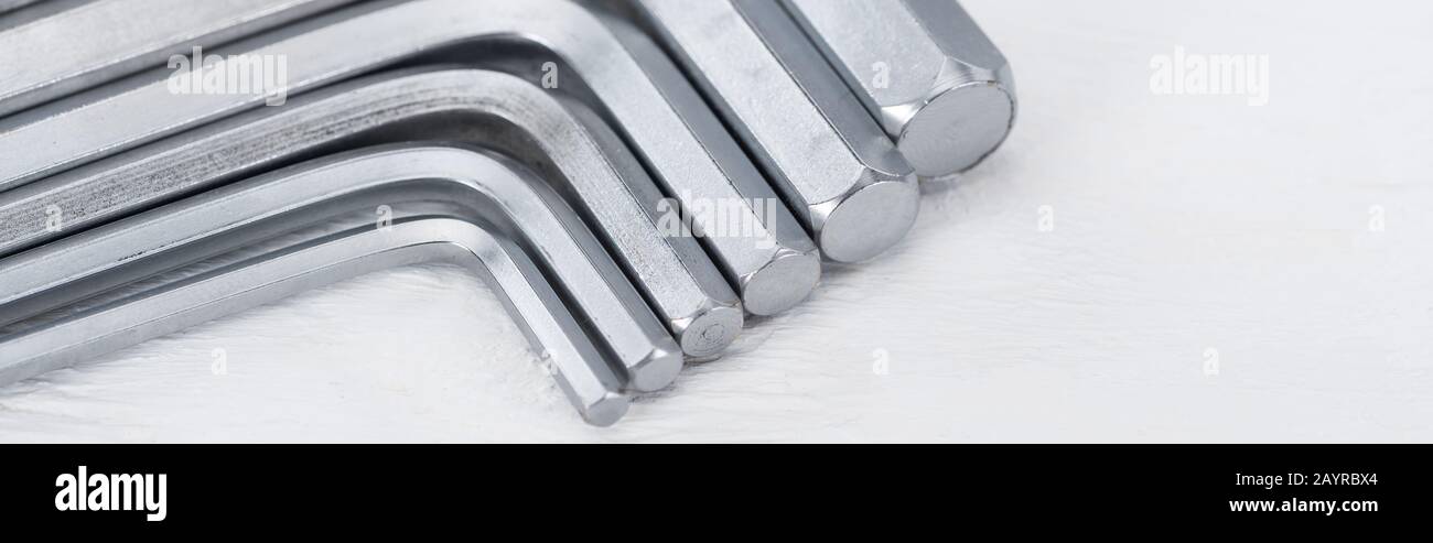 Close up view of hex keys on white wooden background, panoramic shot ...