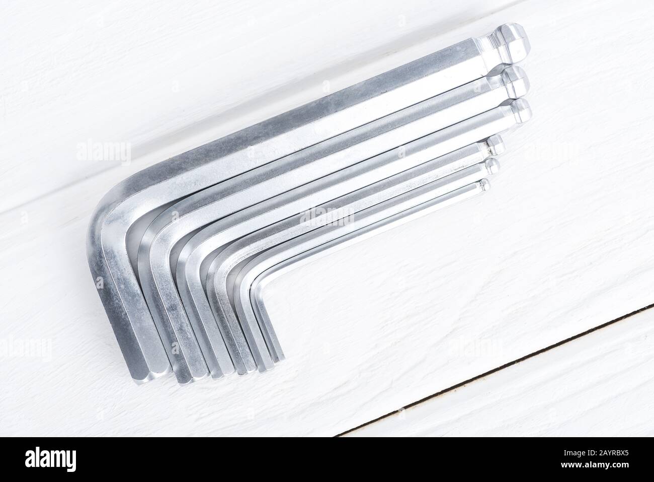 Top view of hex keys on white wooden background Stock Photo - Alamy