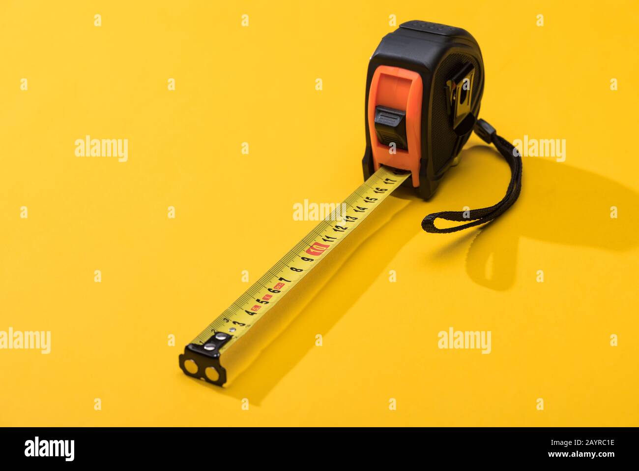 Industrial measuring tape with shadow on yellow background Stock Photo ...