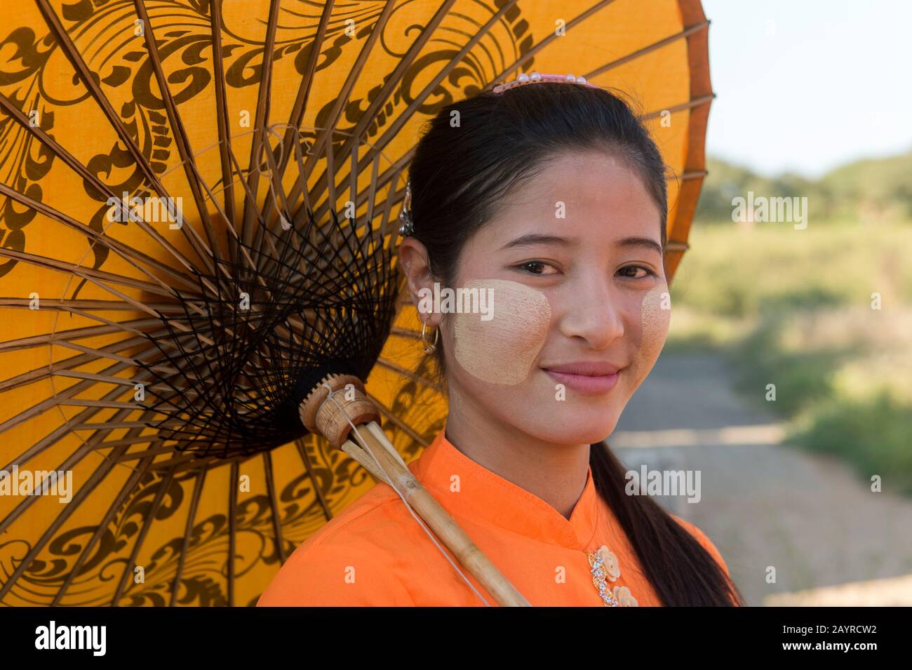 Close-up of a young woman (model) in traditional dress holding a ...