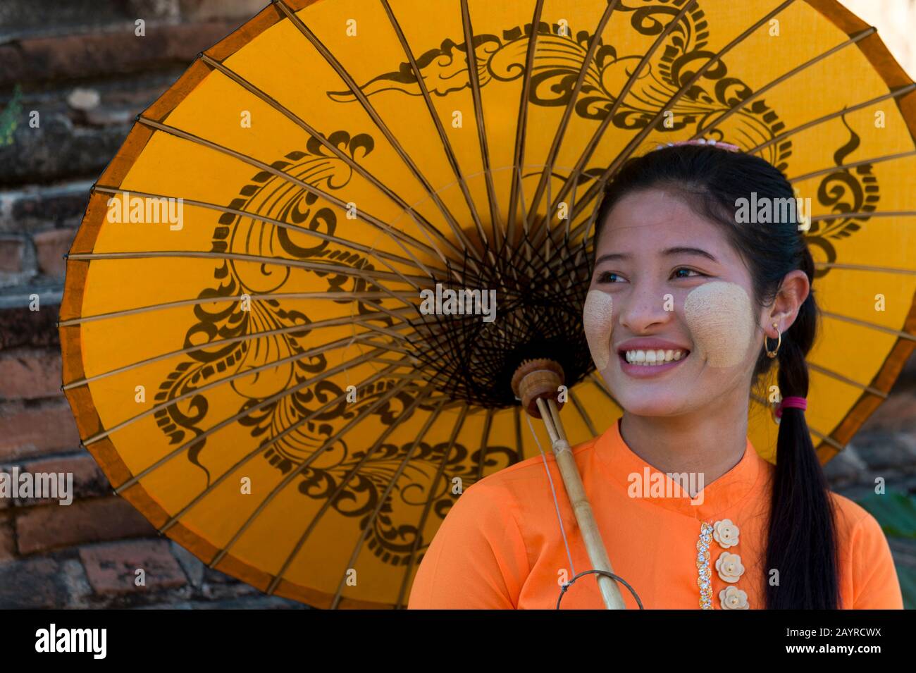 Close-up of a young woman (model) in traditional dress holding a ...