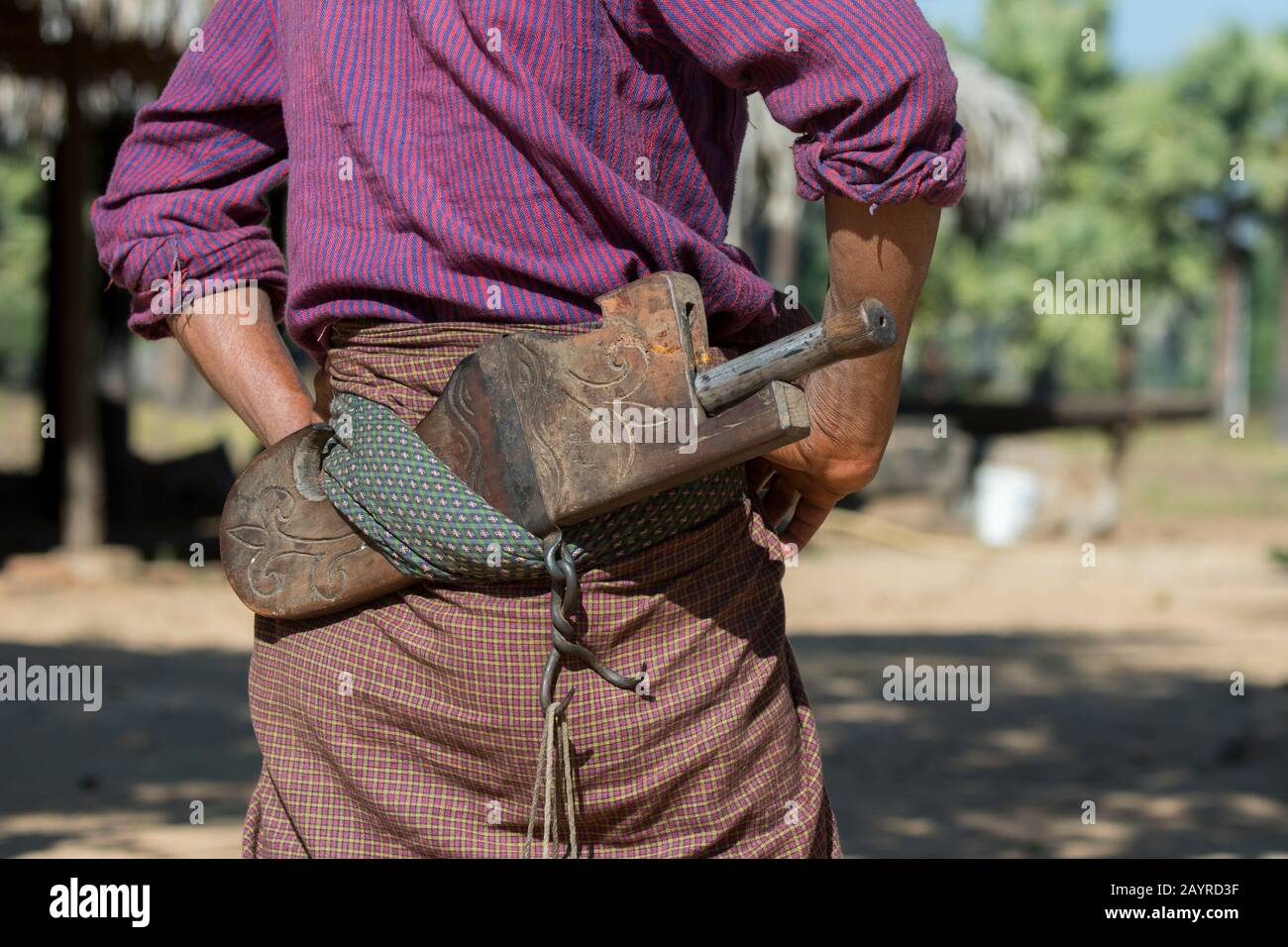The back of a farmer showing the knife holder and knife he uses to cut ...