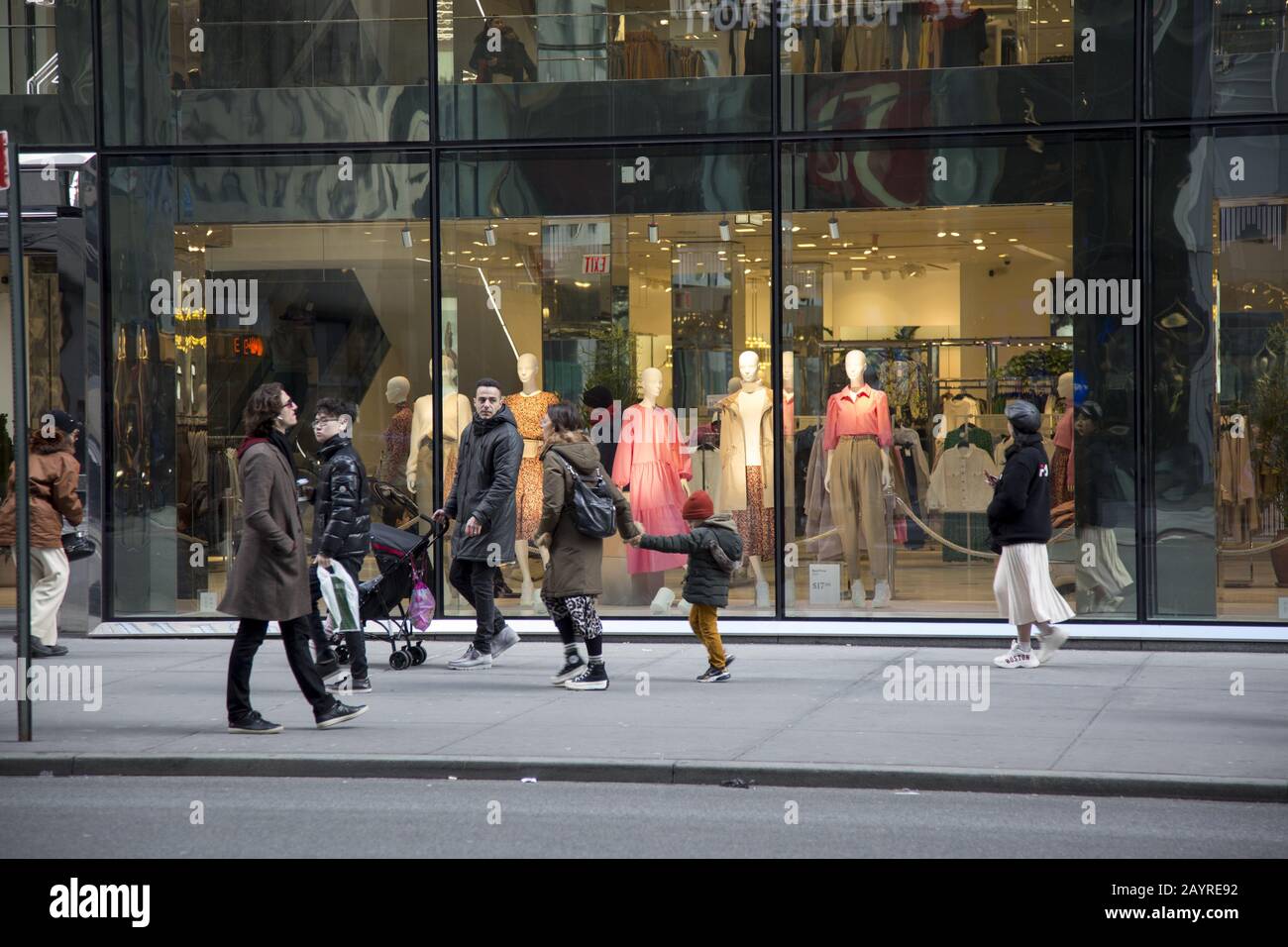 People stroll by fashion boutiques along elegant 5th Avenue in midtown ...