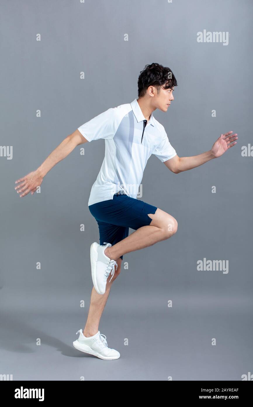 portrait of fitness young man running on the gray background Stock ...