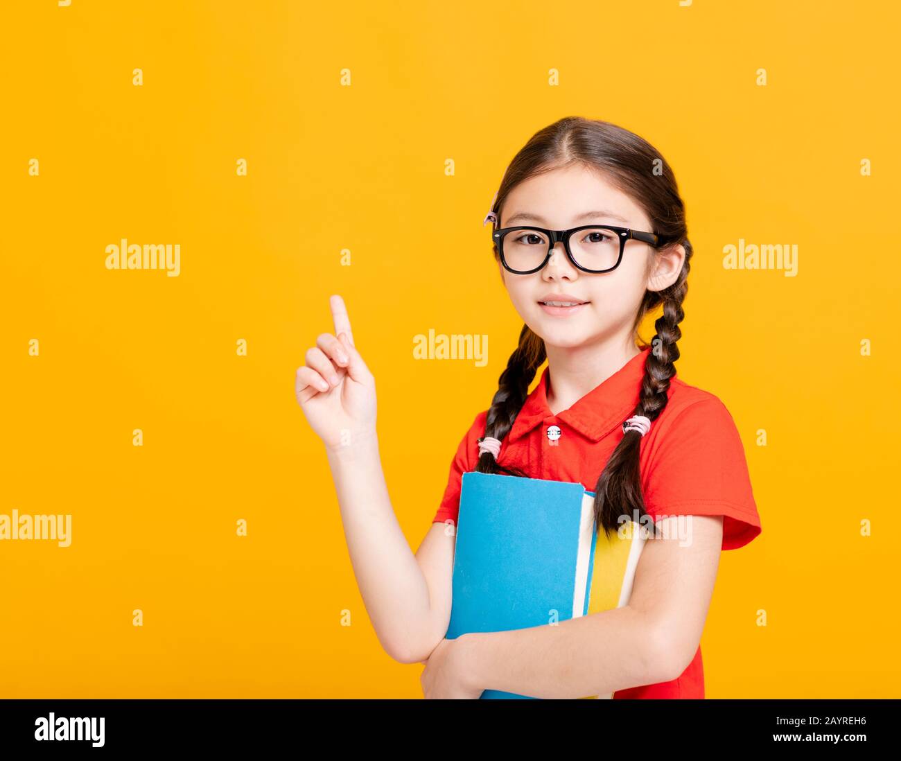Adorable student girl holding the books and showing something Stock ...