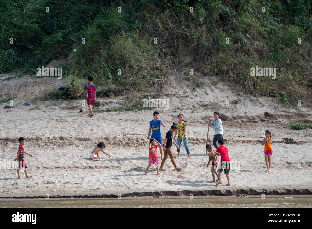 Children playing on the riverbank of the Mekong River near Luang ...
