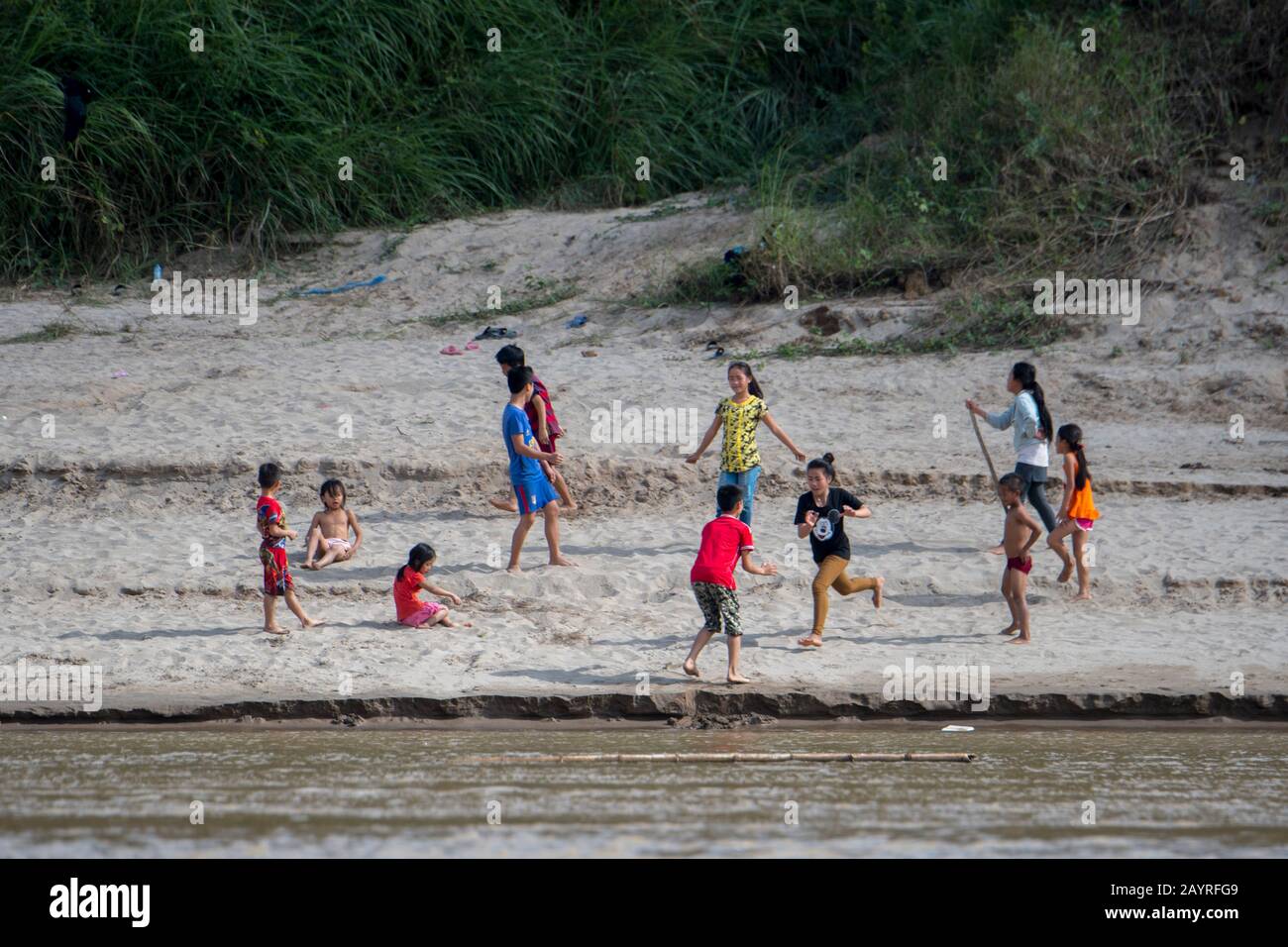 Children playing on the riverbank of the Mekong River near Luang ...