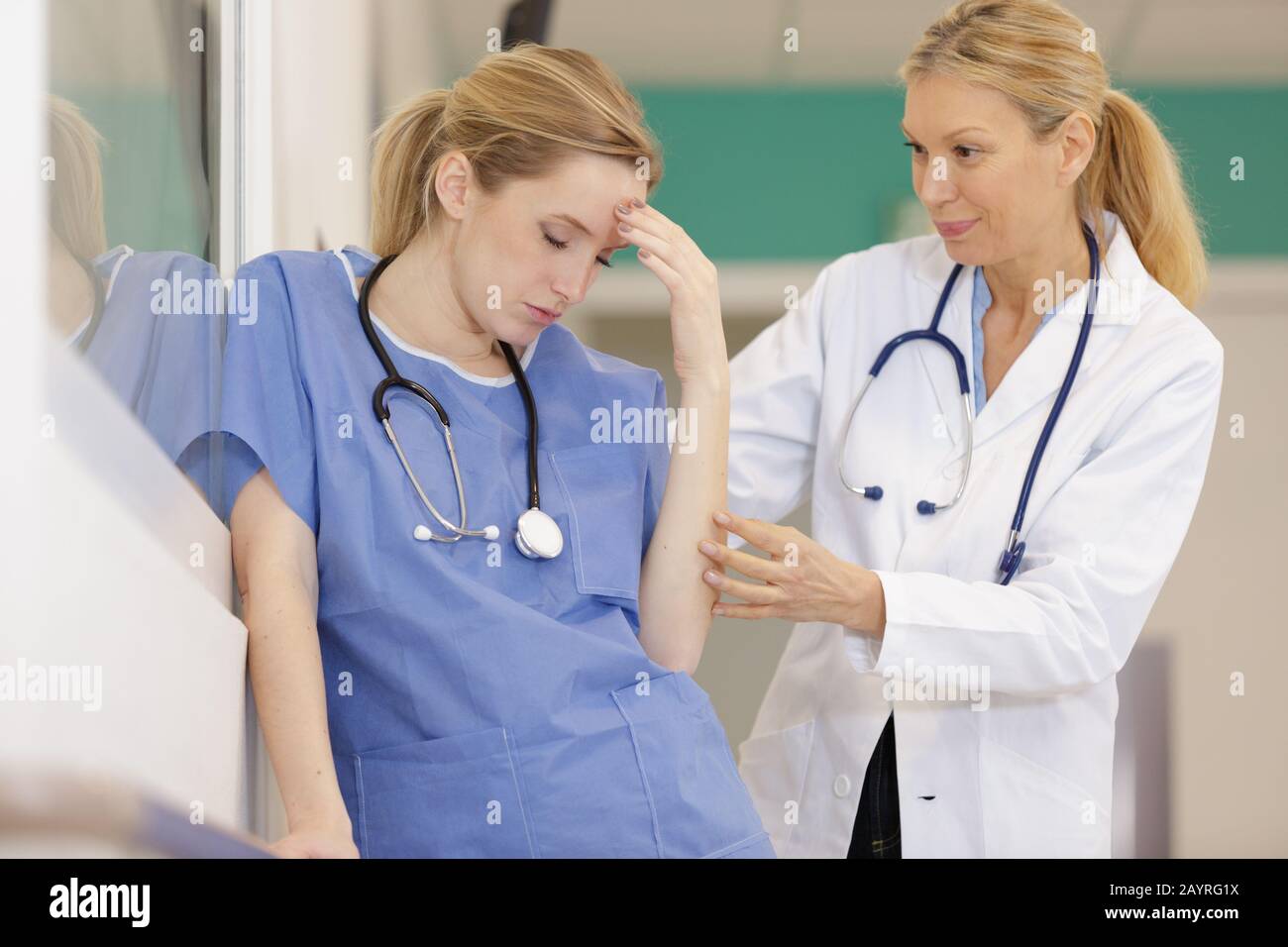 stressed female nurse holding head Stock Photo - Alamy