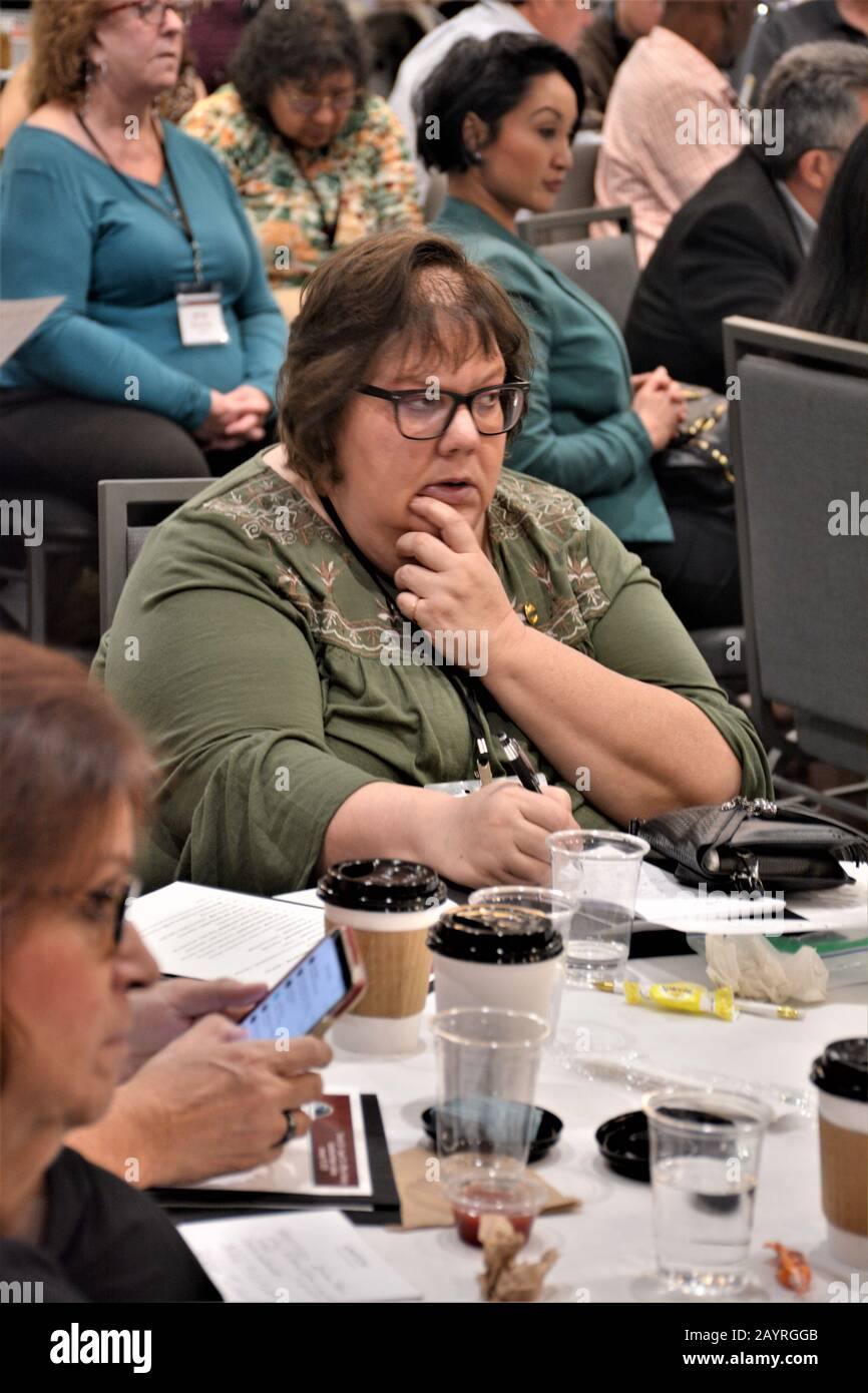 Large heavy lady wearing glasses at gathering learning how to ...