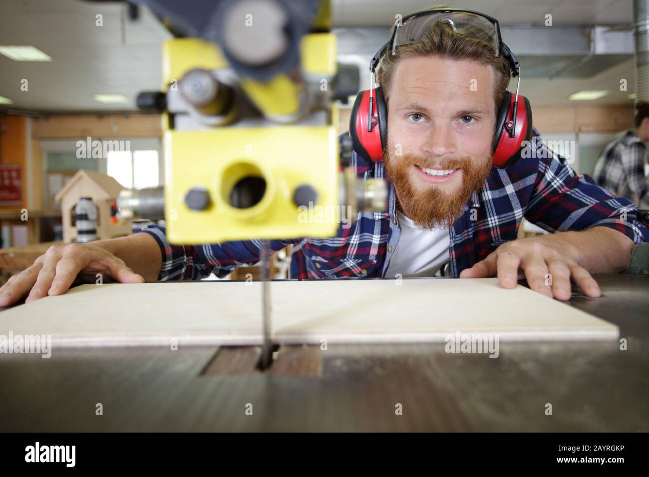 carpenter cutting wooden board with circular saw Stock Photo - Alamy