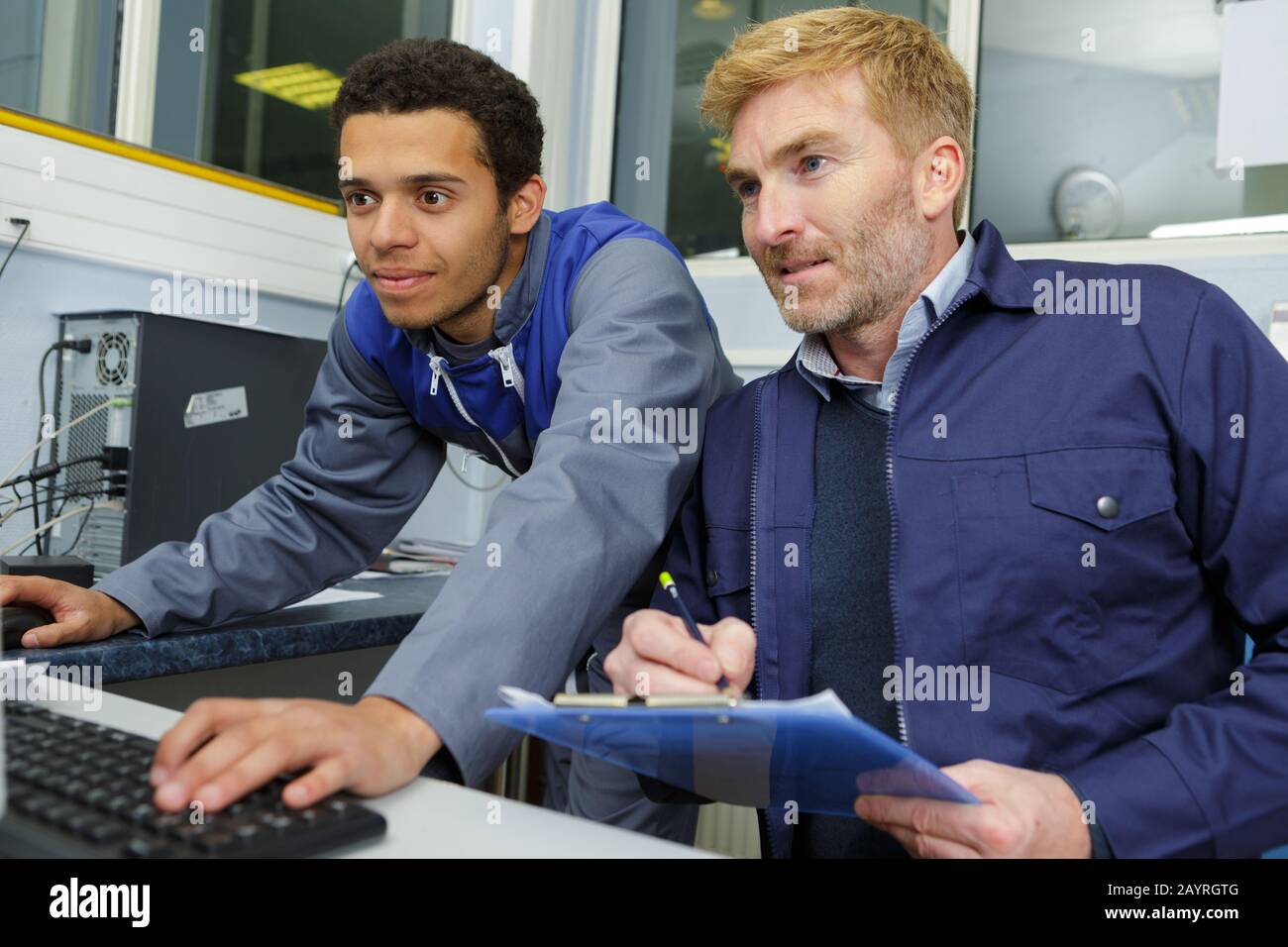 engineers in mechanical office reading instructions Stock Photo - Alamy