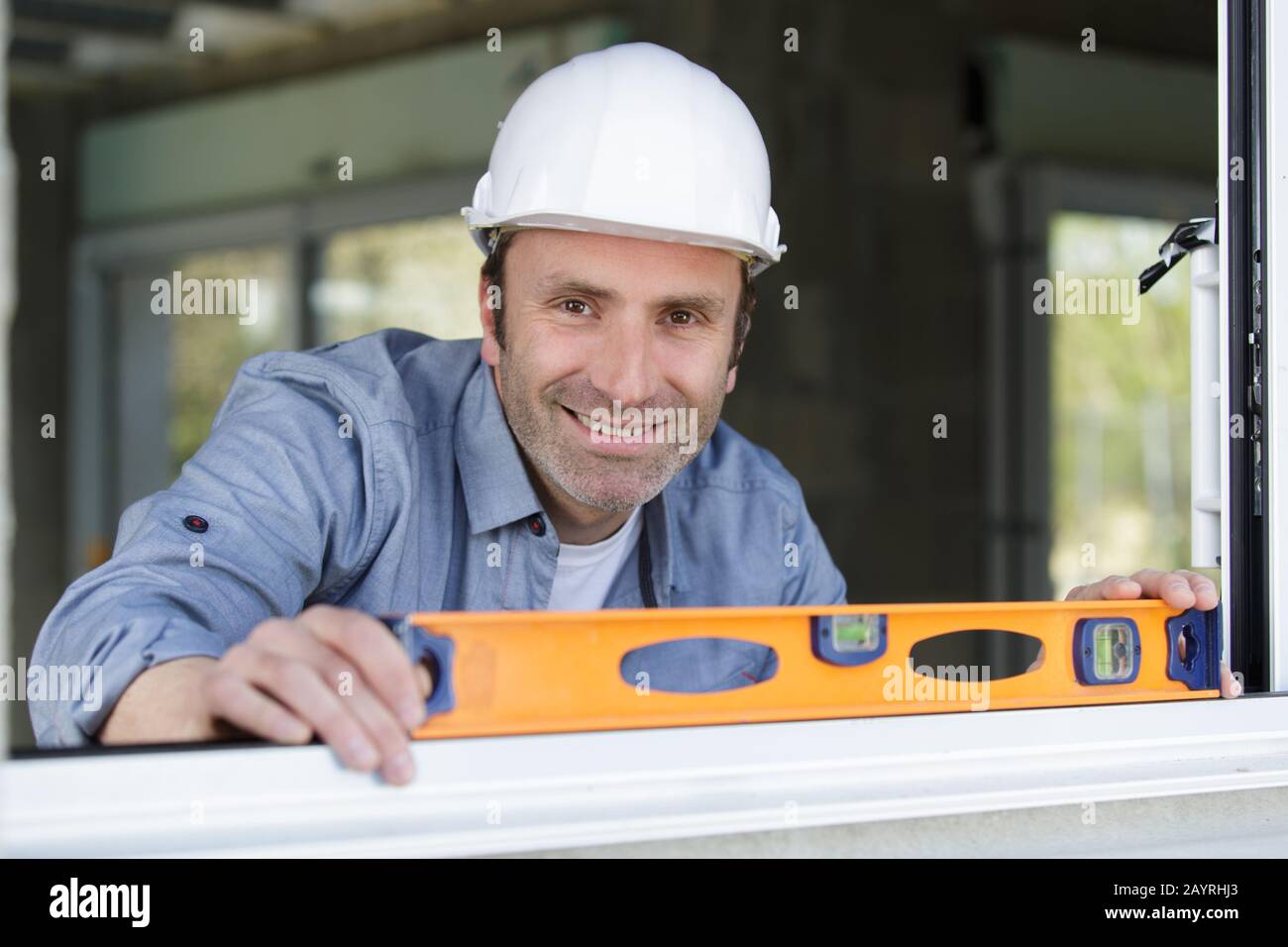 happy smiling constructor holding tool Stock Photo - Alamy